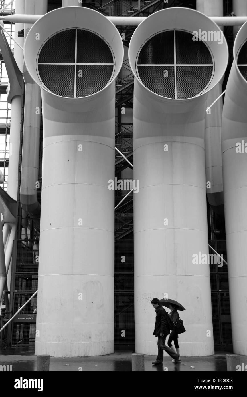 Tourists walking past air conditioning ducts at the rear of the ...
