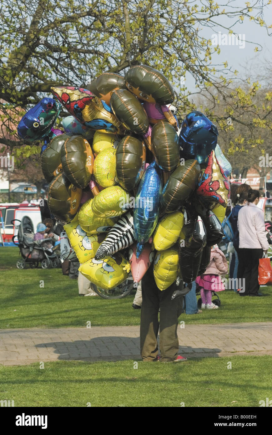 man selling balloons walking through park Stock Photo - Alamy
