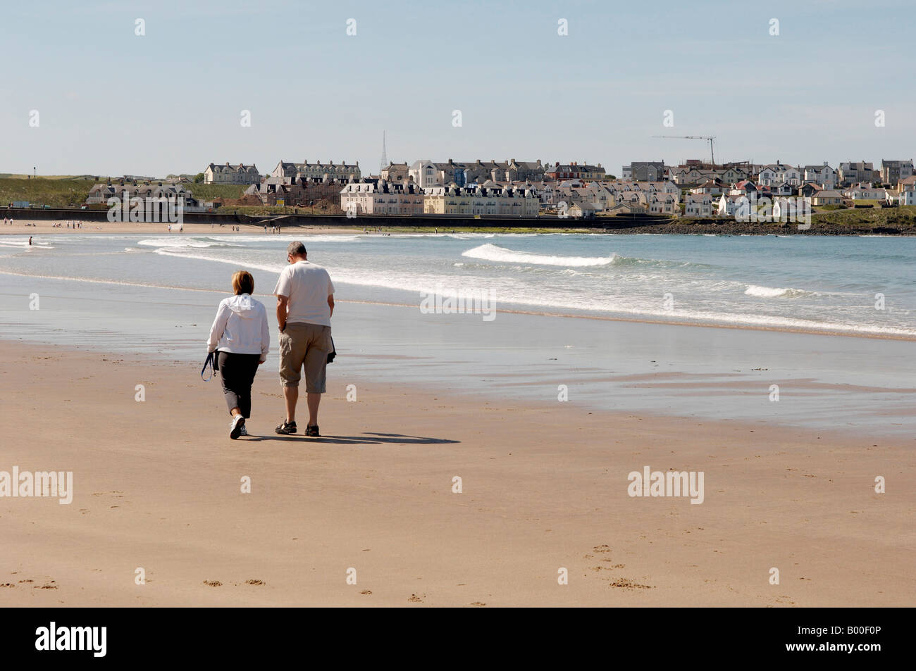 man and woman walking on the beach Portrush Co Antrim Stock Photo - Alamy