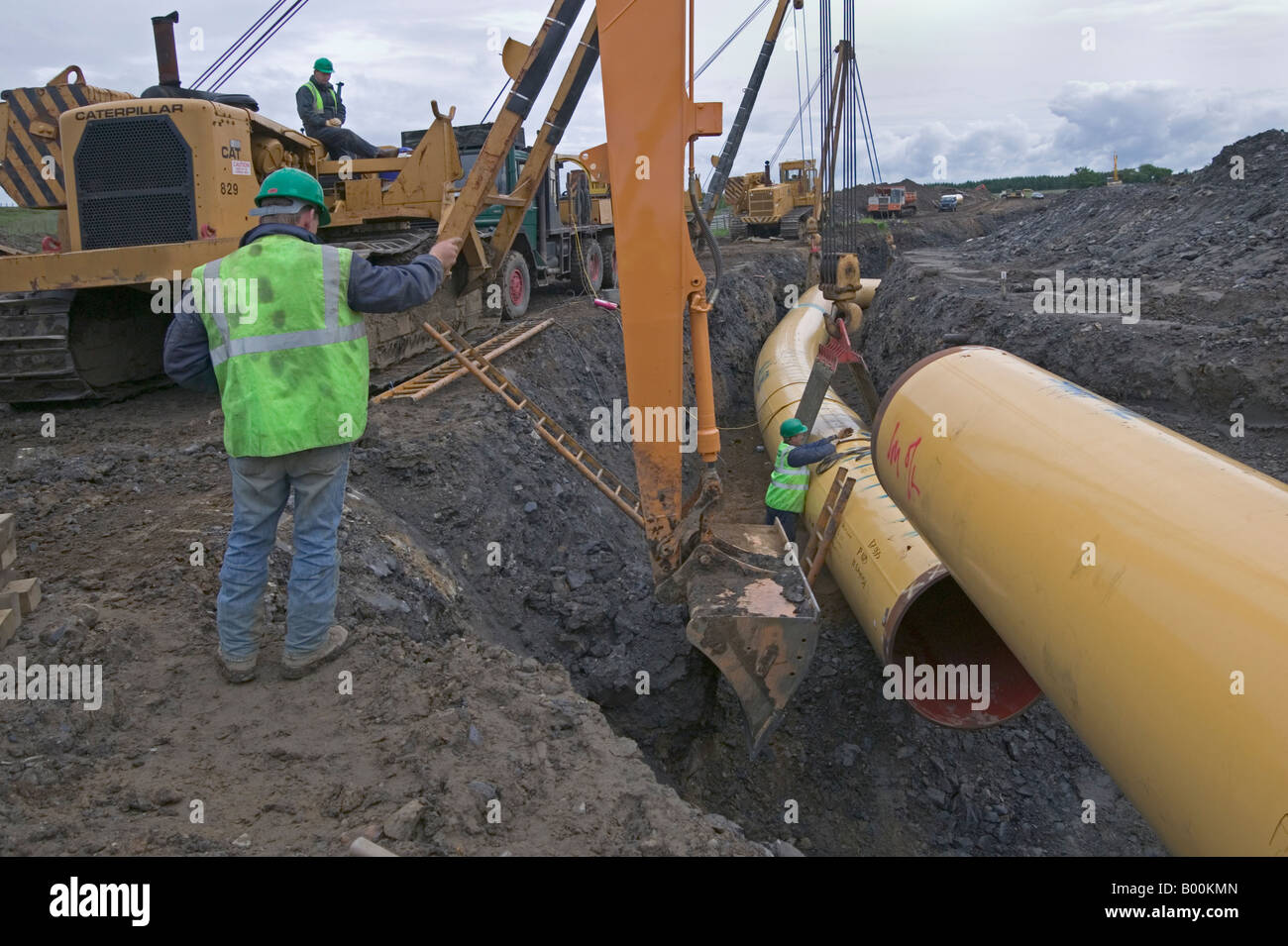 Contractors carefully lowering heavy sections of large diameter, high ...
