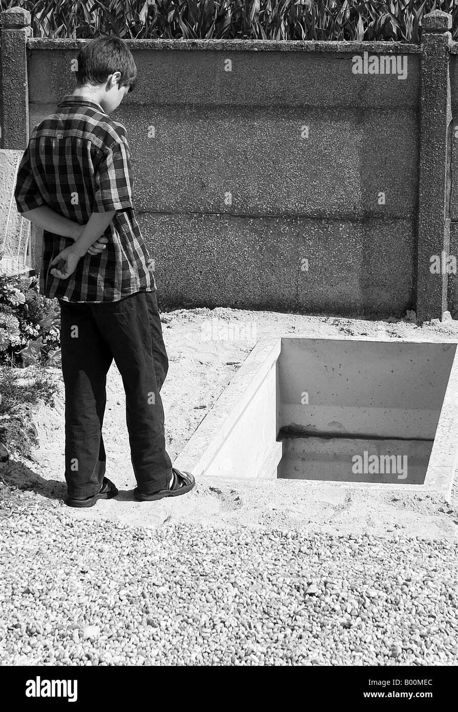 Boy in front of open grave Stock Photo - Alamy