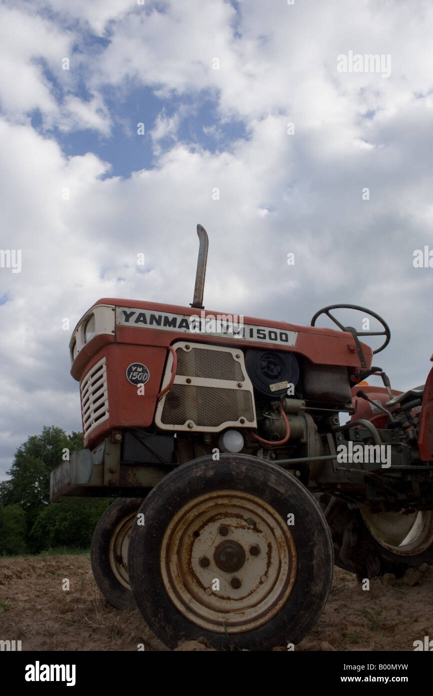 Small tractor down on the farm with clouds Stock Photo - Alamy