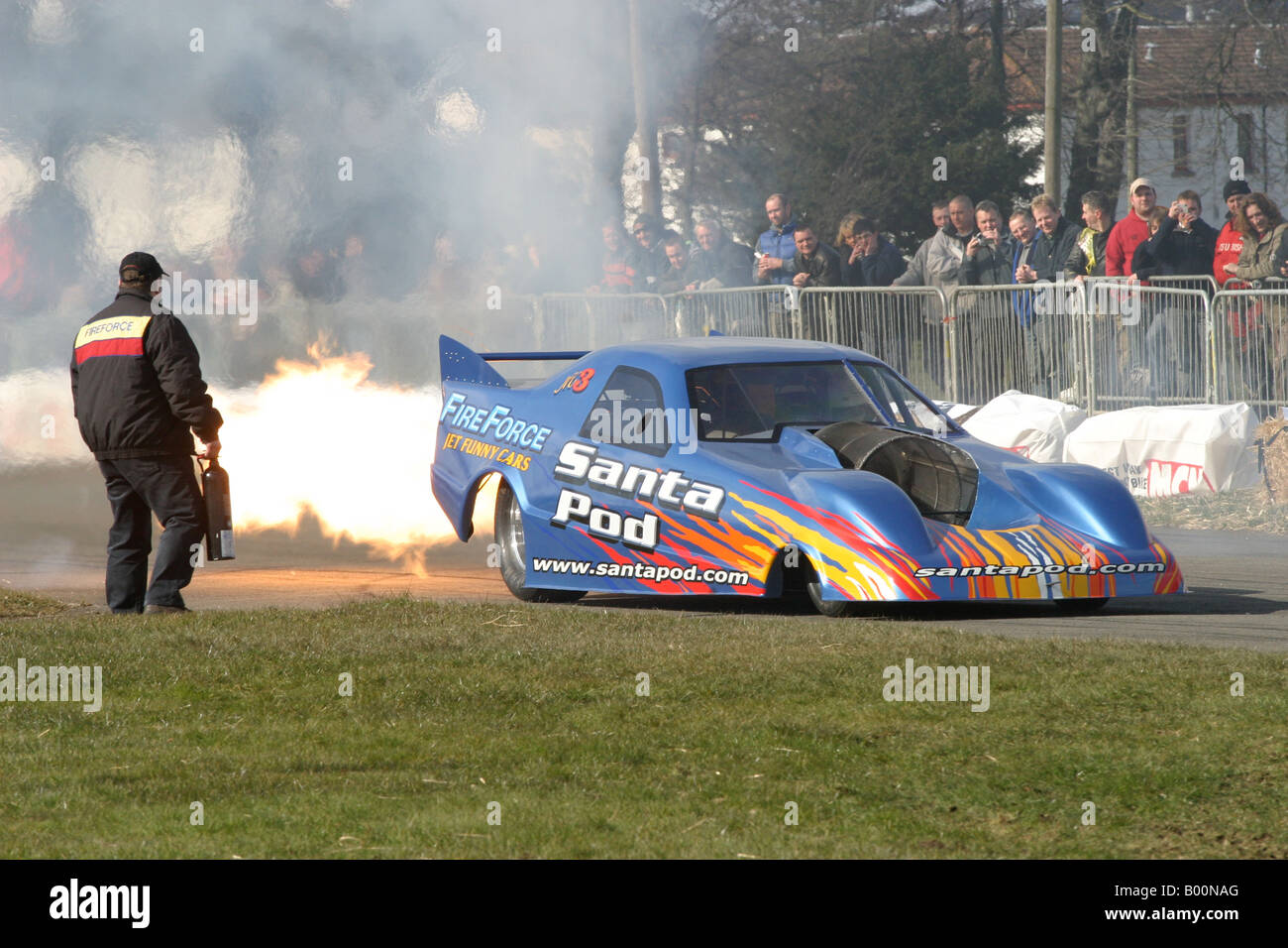 a mechanic stands by with a fire extinguisher whilst a jet power car ...