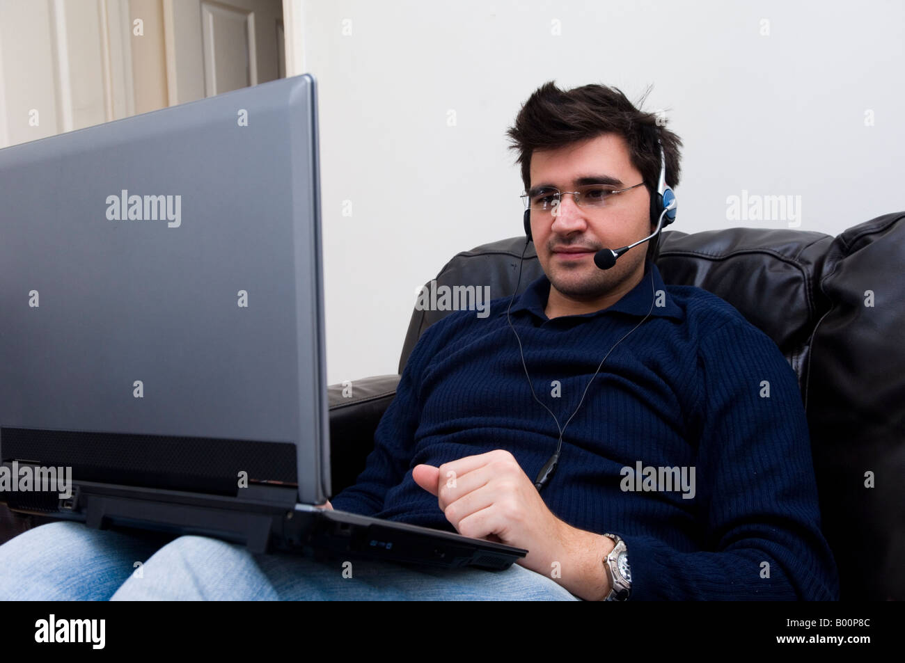 Man with headphone using laptop computer Stock Photo - Alamy