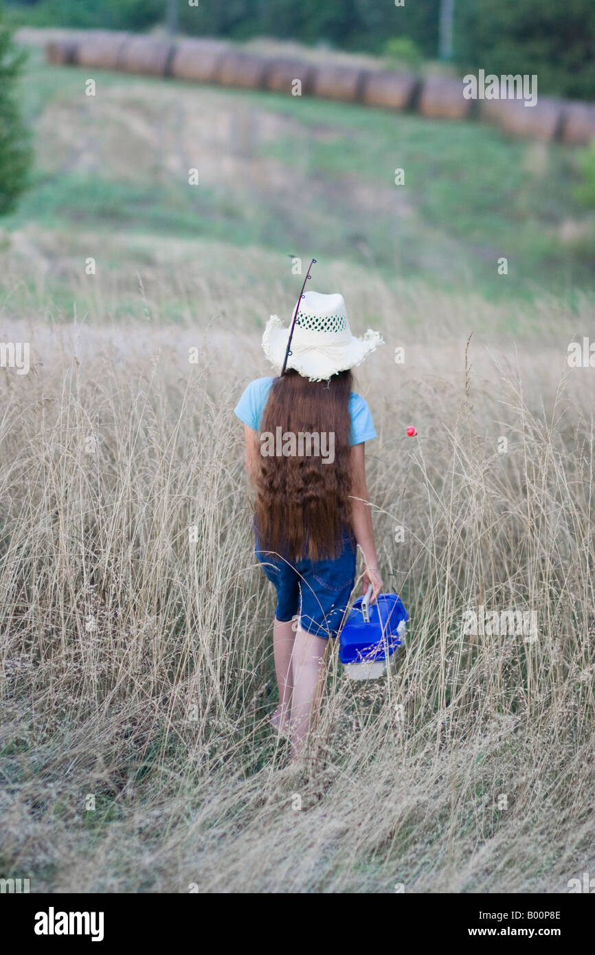 Young girl carrying a fishing pole and tackle box Stock Photo - Alamy