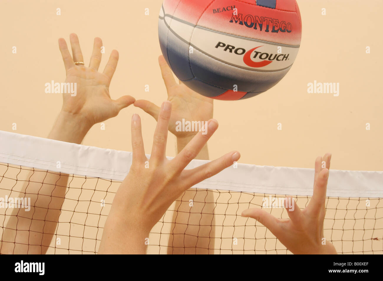 Hands and ball at the net playing volleyball indoor Stock Photo - Alamy