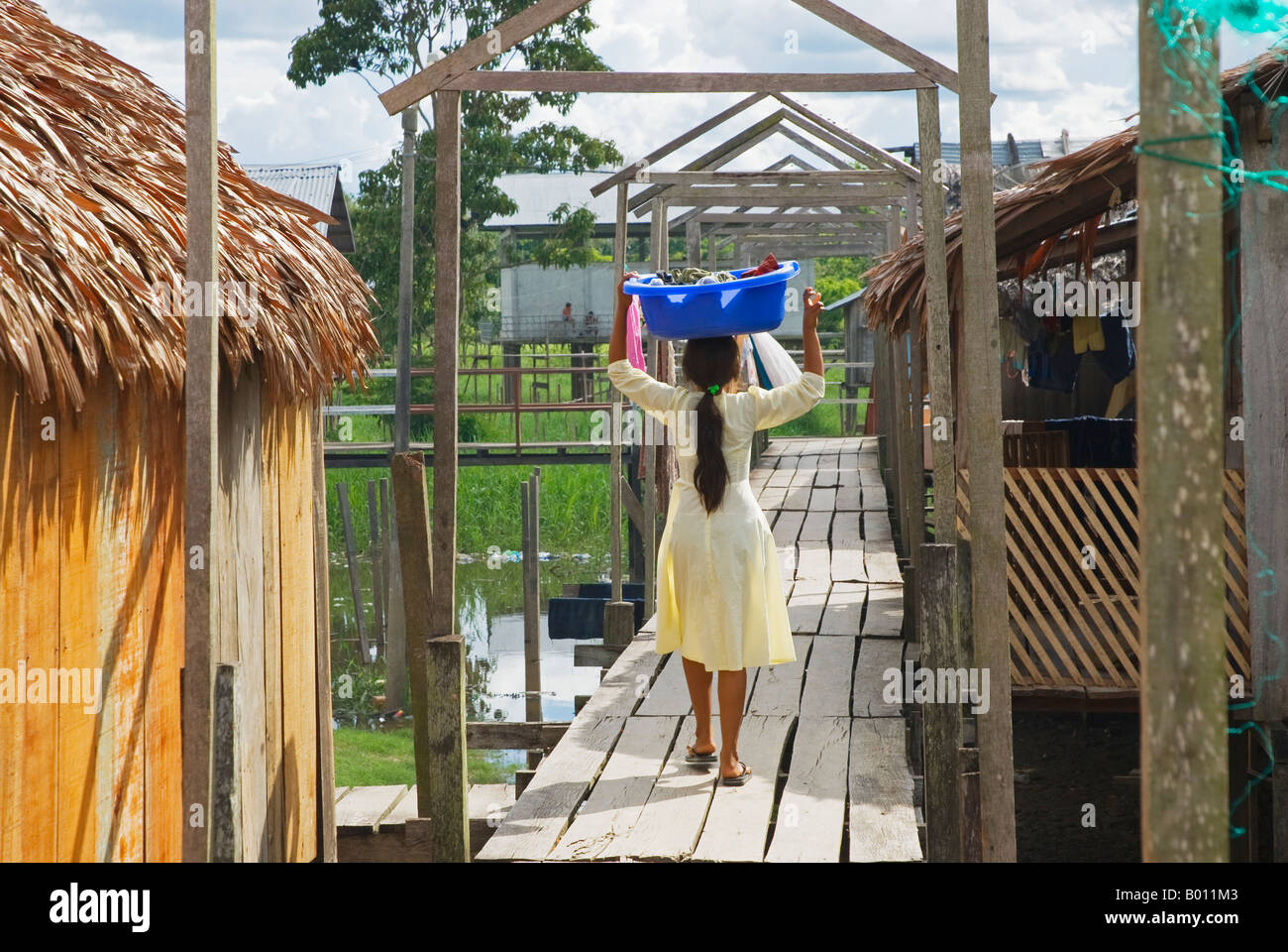 Peru, Amazon River. Indigenous Indian girl carrying her washing in the ...
