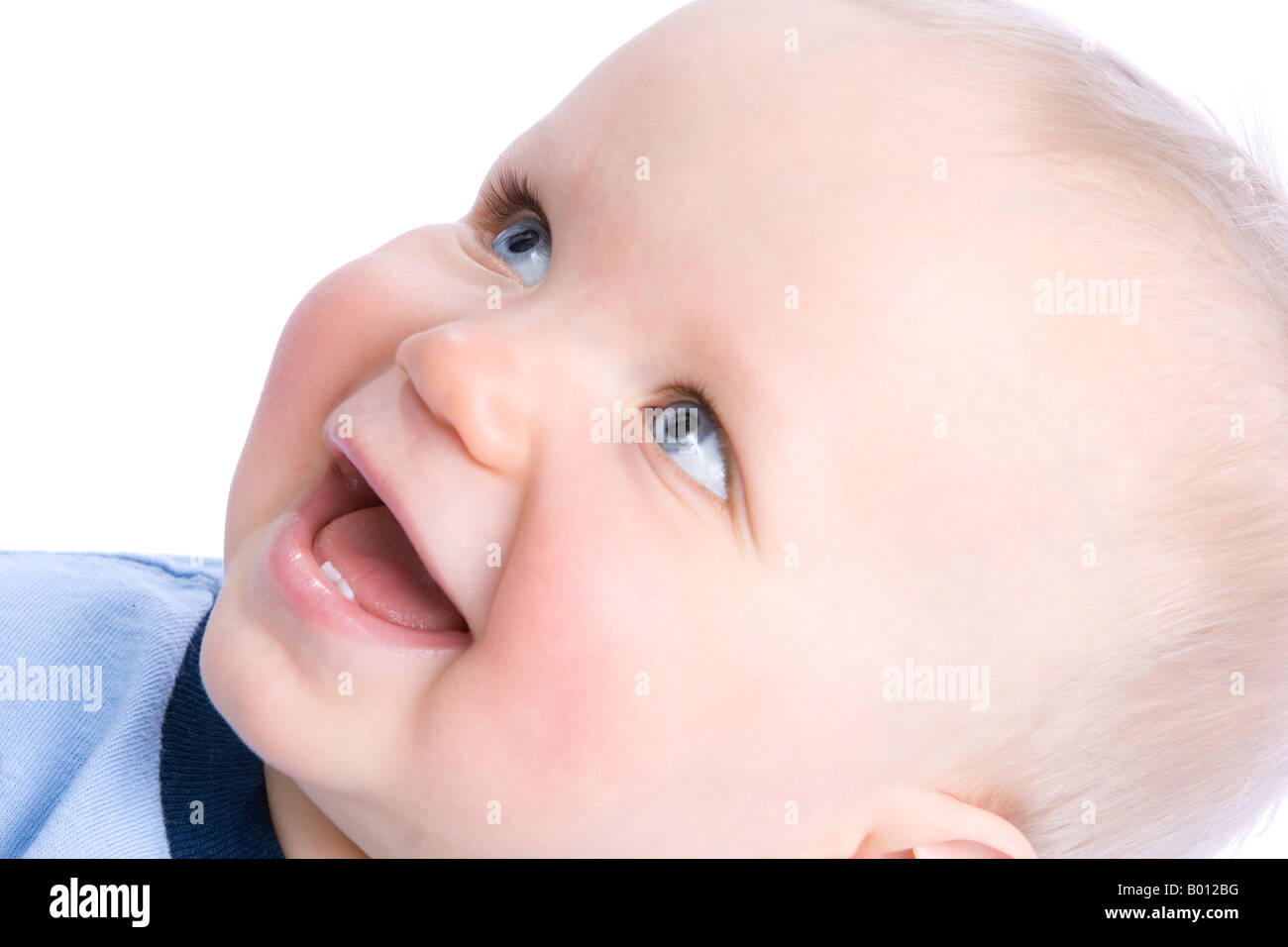 Cute baby looking diagonally and laughing showing two teeth. Shallow ...