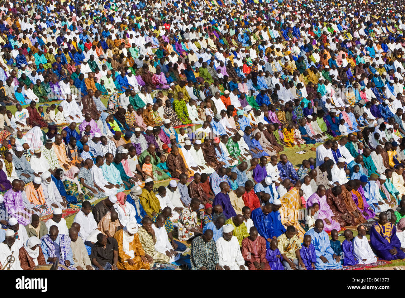 Mali, Mopti. A huge gathering of brilliantly dressed Muslim men kneel ...