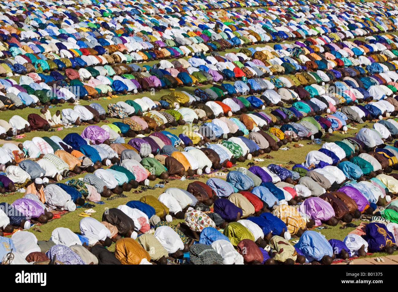 Mali, Mopti. A huge gathering of brilliantly dressed Muslim men pray to ...