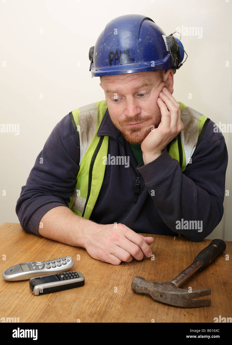 Builder sits by the phone waiting for some work as the economy slows ...