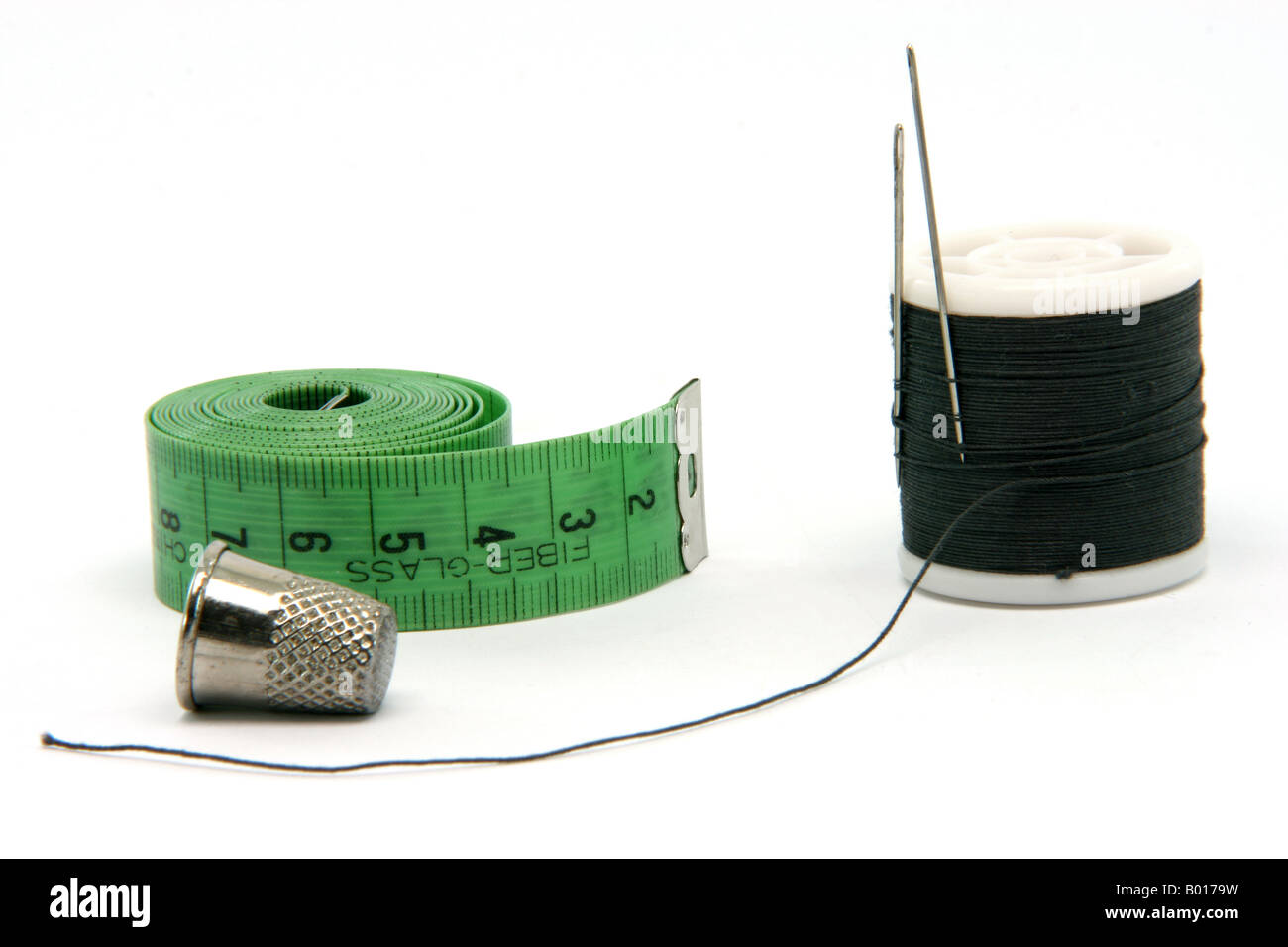 sewing items measure tape thread and thimble isolated on white ...