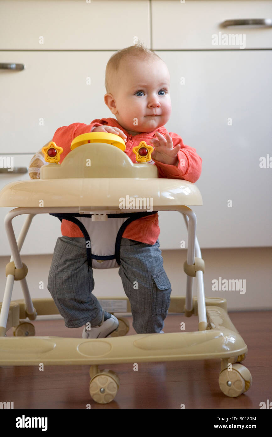 Baby boy walking in a babywalker Stock Photo - Alamy