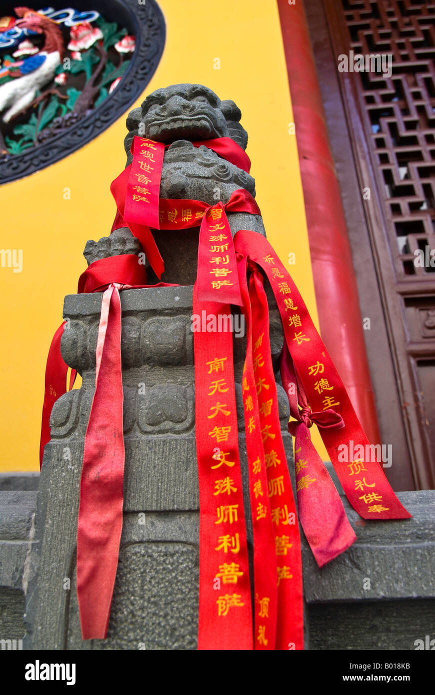 Red prayer ribbon offerings tied to stone lion, Jade Buddha Temple ...