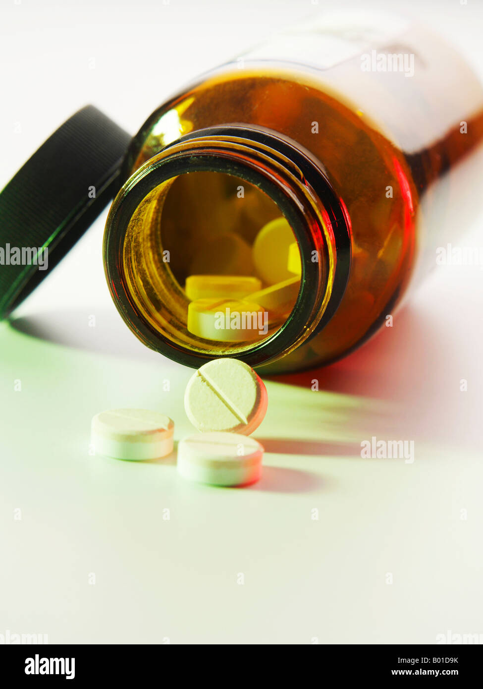 Front view of pill spill out from an open bottle Stock Photo - Alamy