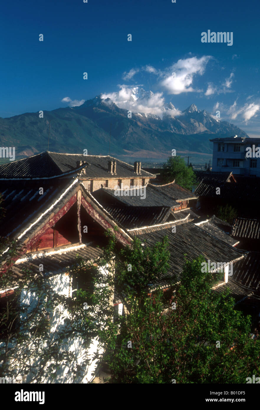 Lijiang Old Town rooftops with Jade Dragon Snow Mountain in distance in ...