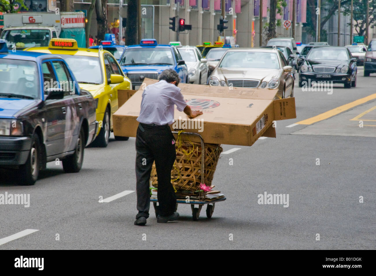 Asian man pushing basket down street in Singapore Stock Photo - Alamy