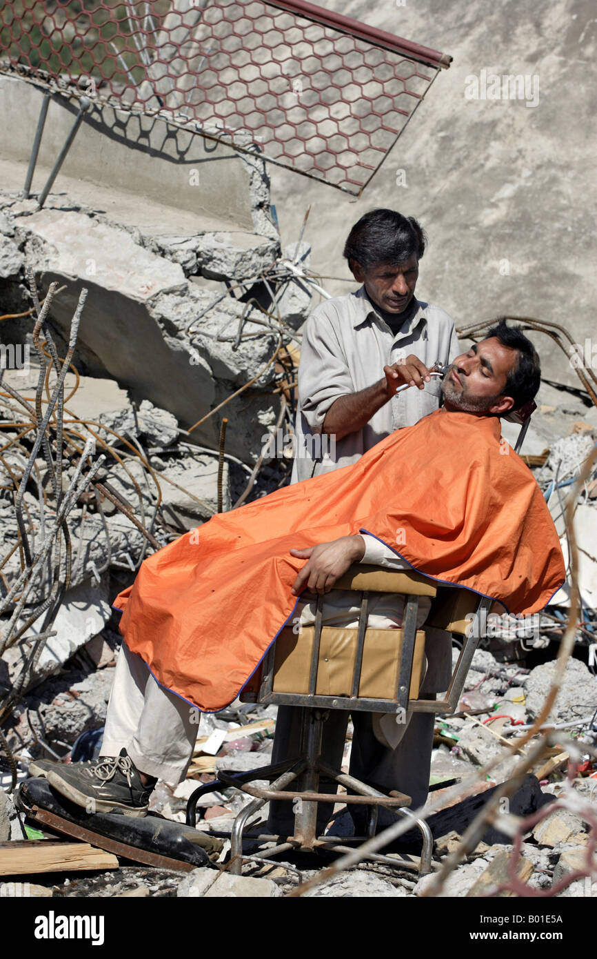 Barber shaving his customer in the ruins of Balakot, Pakistan Stock ...
