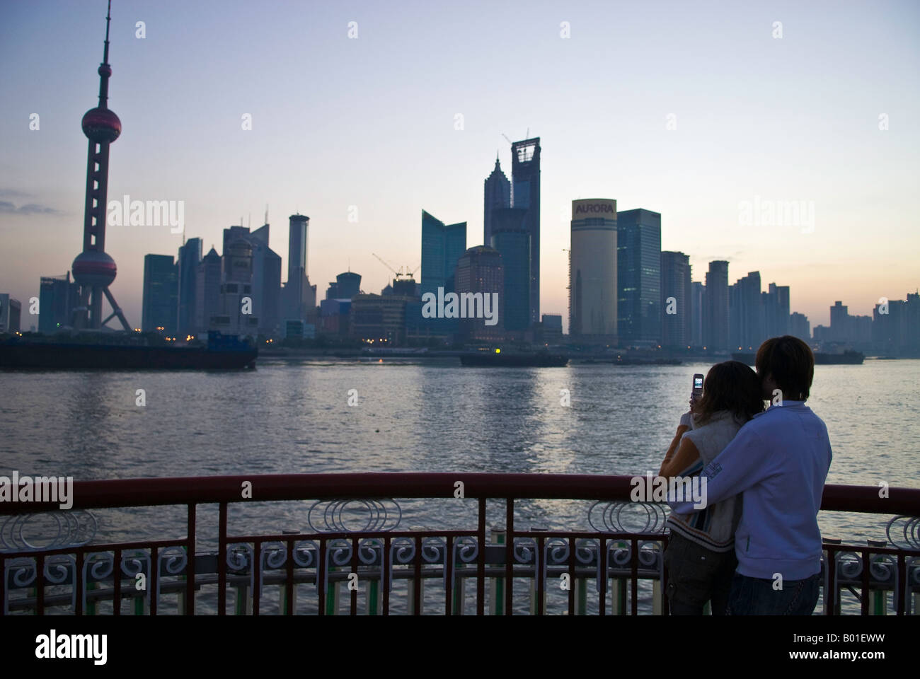 Young couple kiss and cuddle along skyline, The Bund, Shanghai, China ...