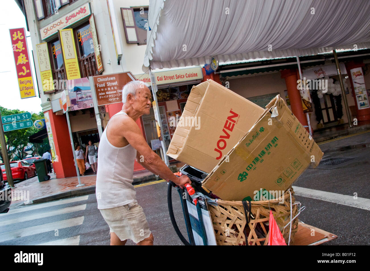 Asian man pushing basket down street in Singapore Stock Photo - Alamy