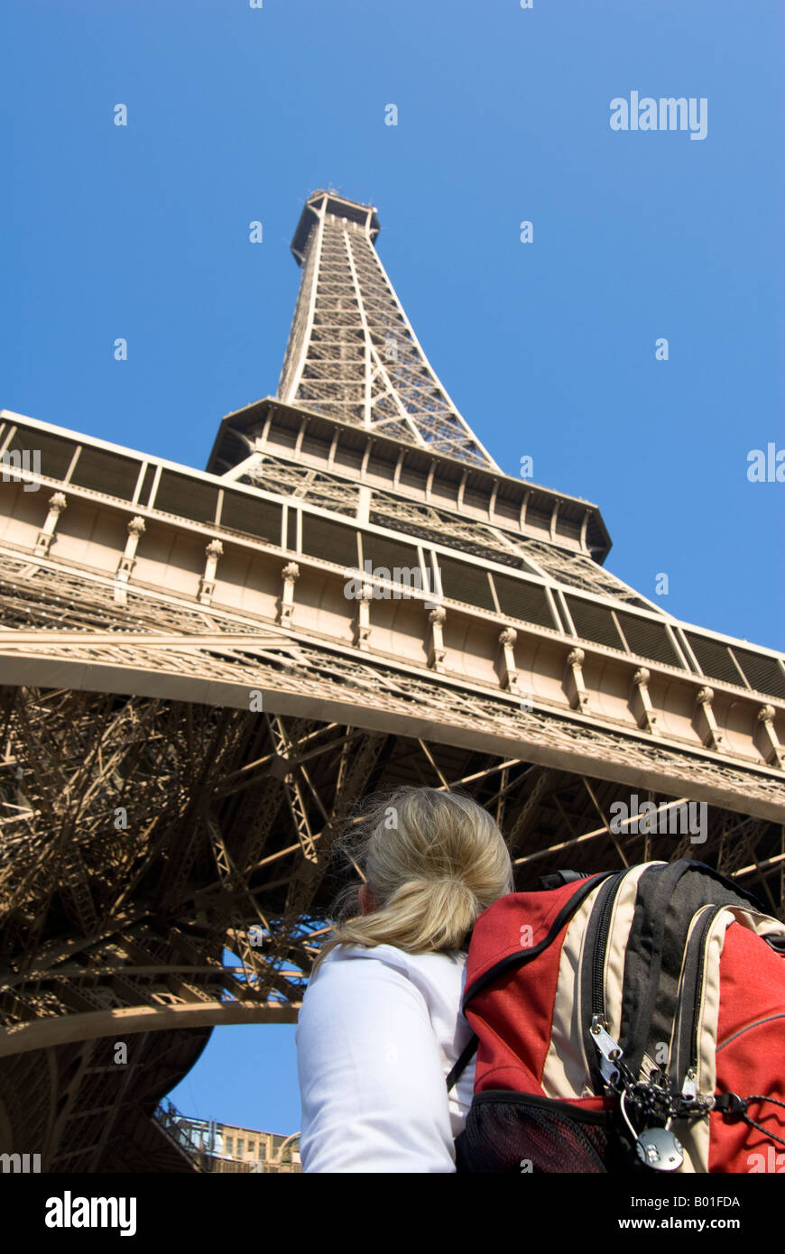 Female backpacking tourist looking up at the Eiffel Tower Paris France ...