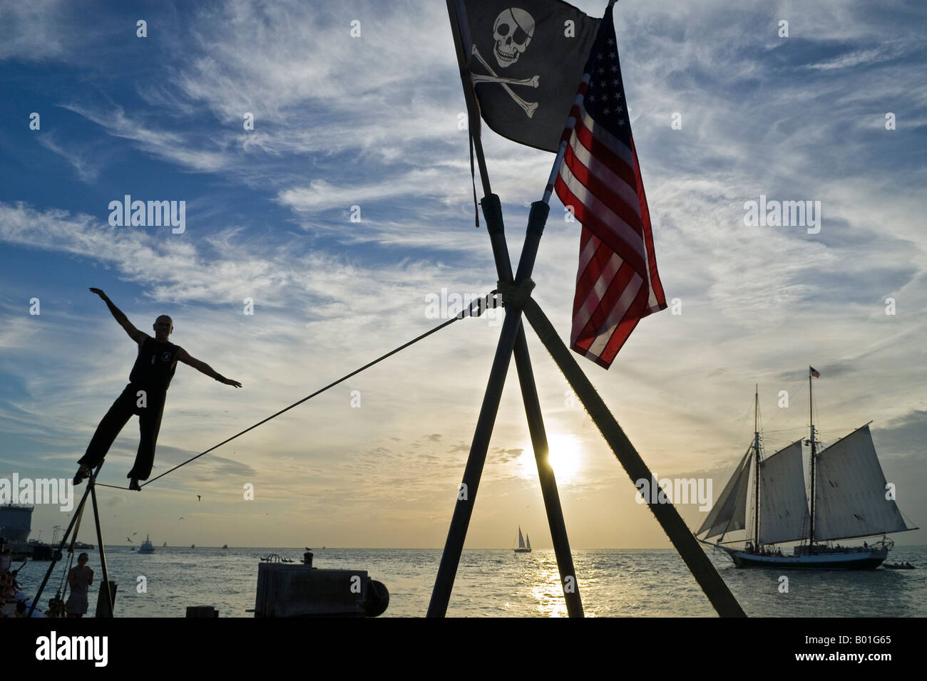 Tightrope walker juggles over ocean at sunset, Mallory Square, Key West ...