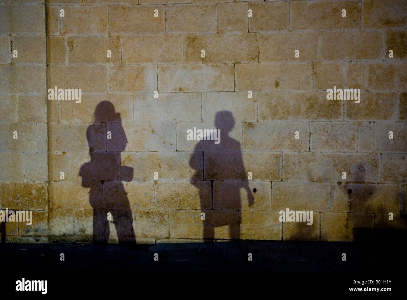 Night time shadows of tourist photographer and elderly local woman on ...