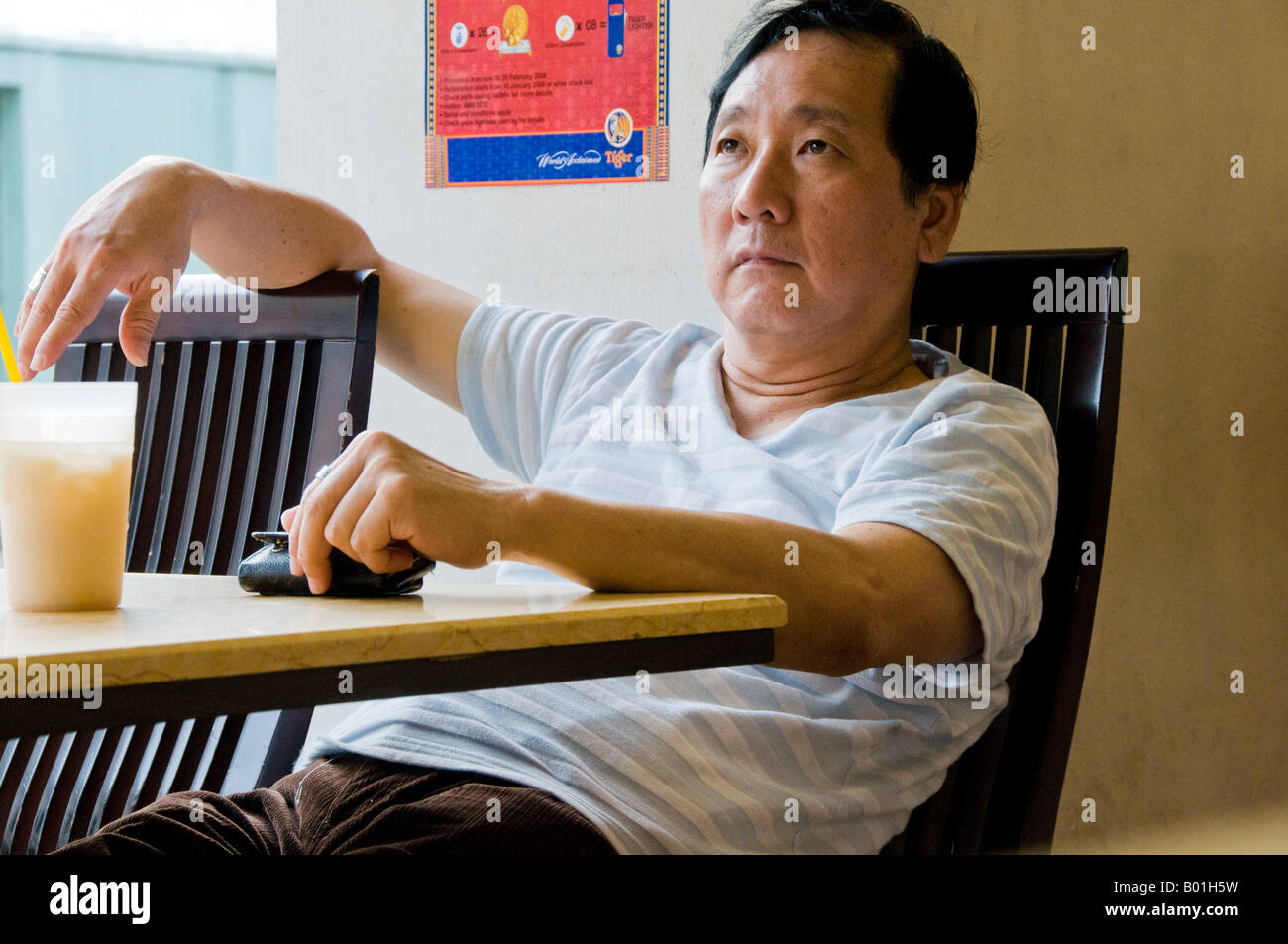Handsome Asian man sitting down at restaurant in Singapore Stock Photo ...