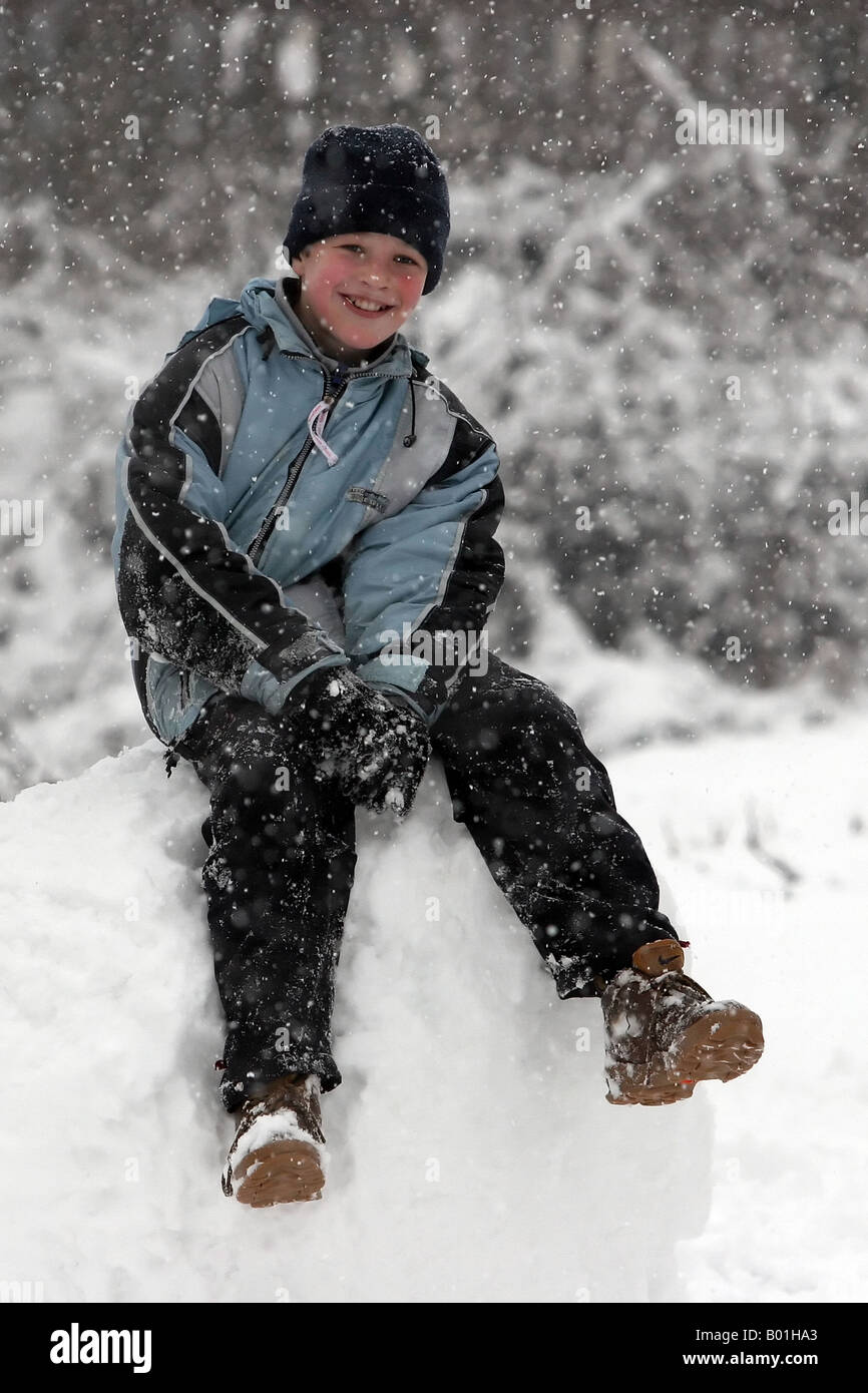 Children rolling snowball snowman hi-res stock photography and images ...