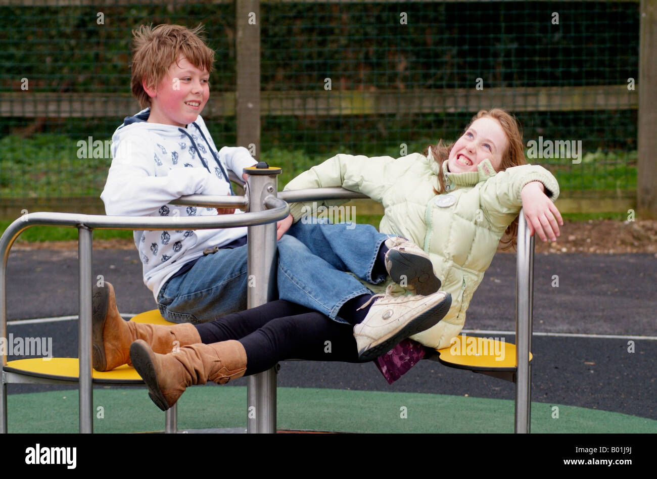 Childrens Playground Boy and Girl Having Fun on a Roundabout Stock ...
