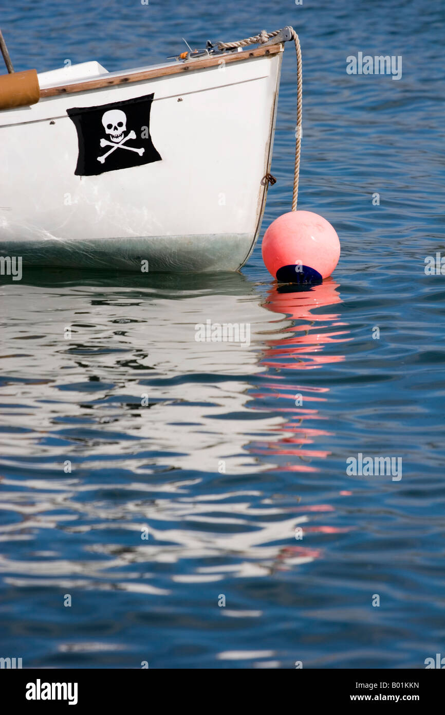 Skull and cross bones on small rowing boat with reflection Stock Photo ...