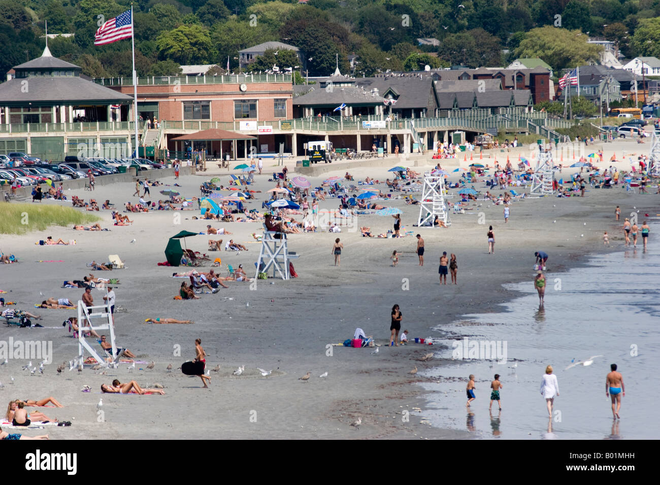 A crowd of people play and sunbath at a beach in Newport, Rhode Island ...