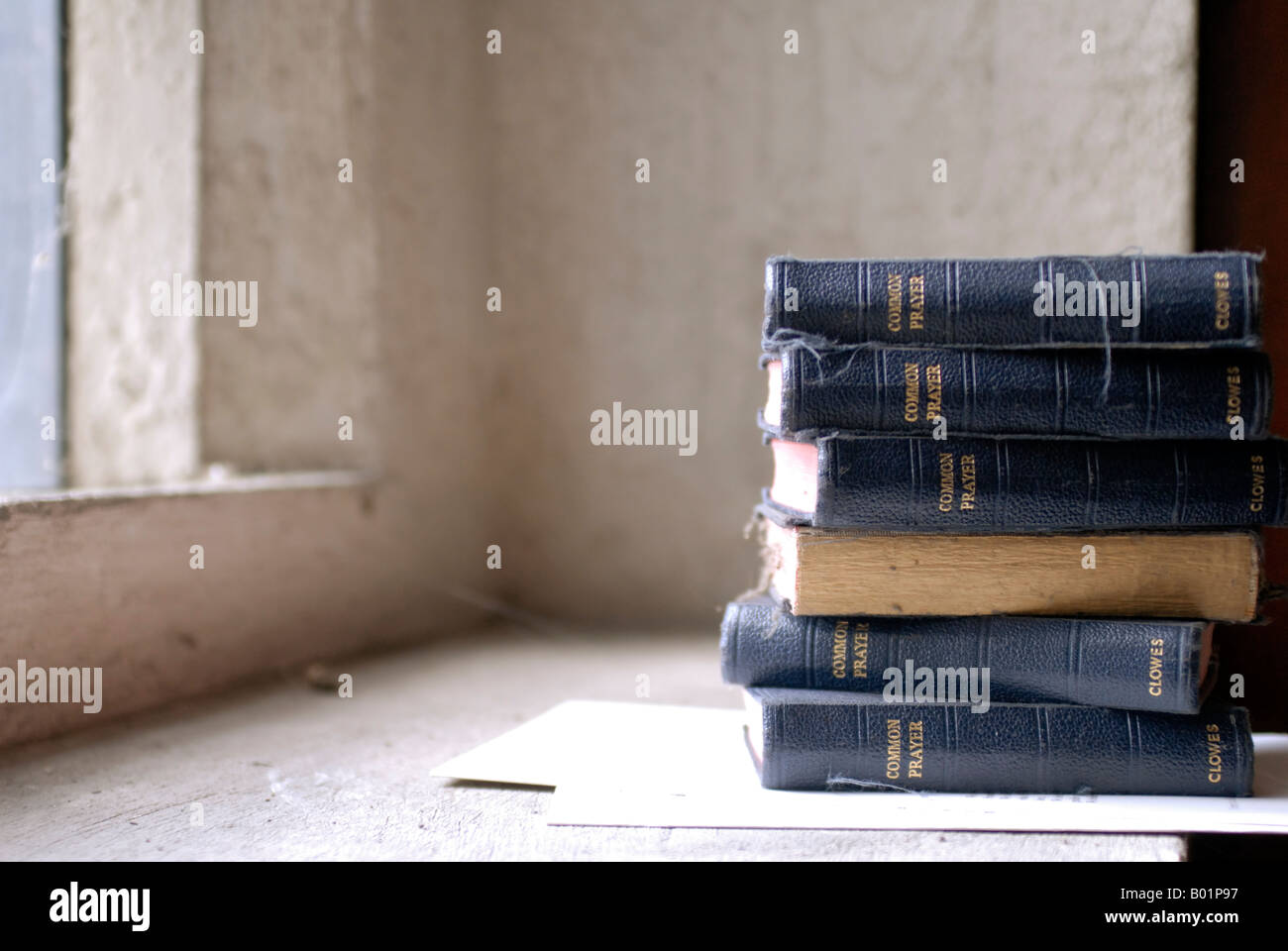 Stacked navy blue common prayer books on window sill in church Stock ...