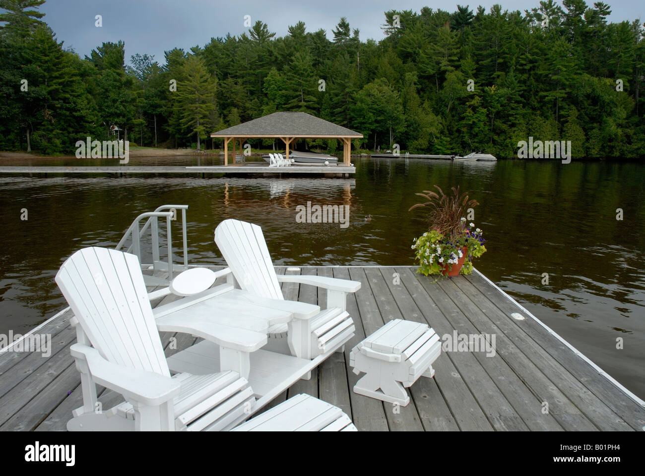 Two Muskoka Chairs on a dock in a beautiful northern, Canadian Lake ...