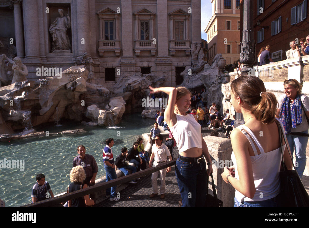 trevi fountain with young blond girl throwing coins into the fountain ...