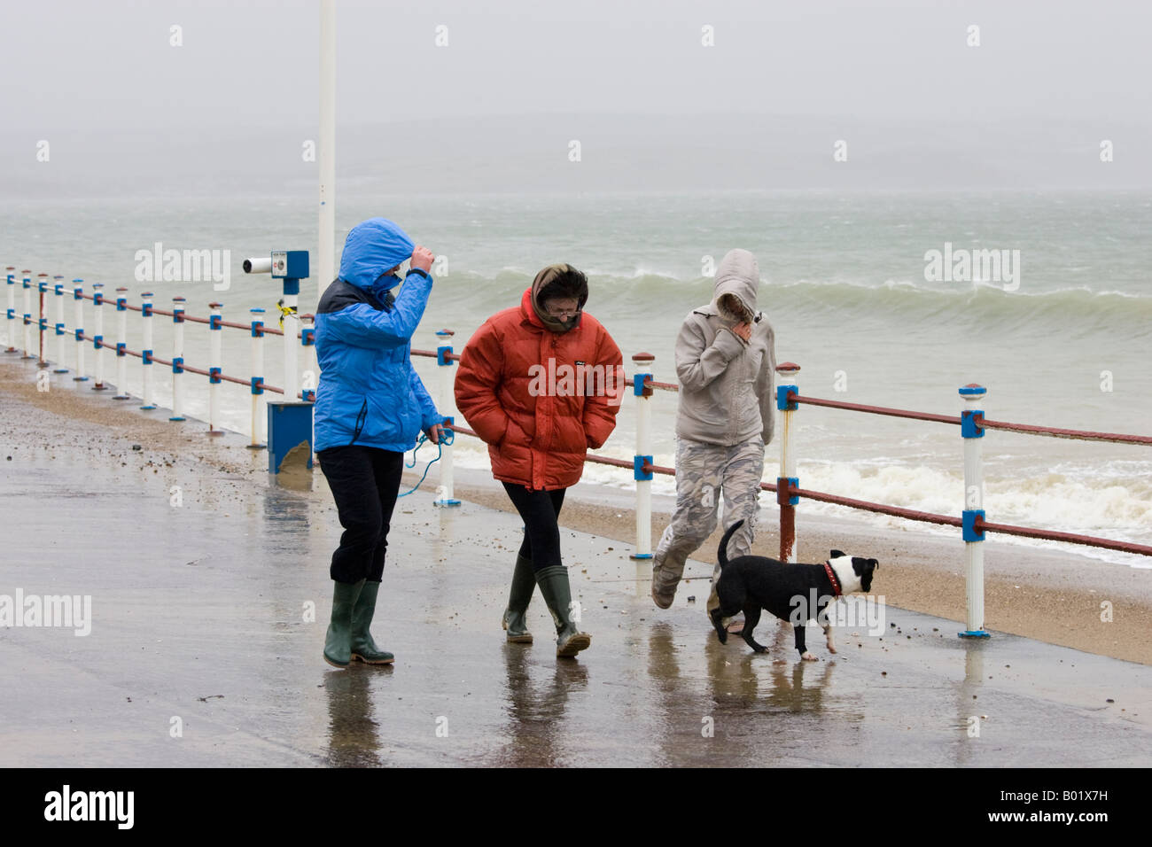 Walkers on promenade during storm Stock Photo - Alamy