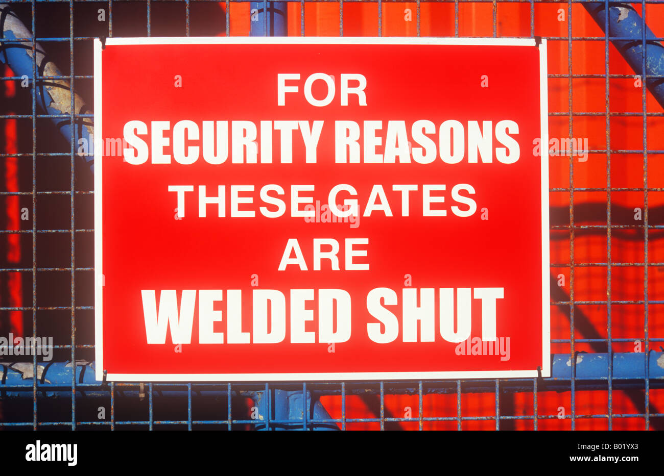 Sign on steel and wire mesh gate and barricaded by metal container ...