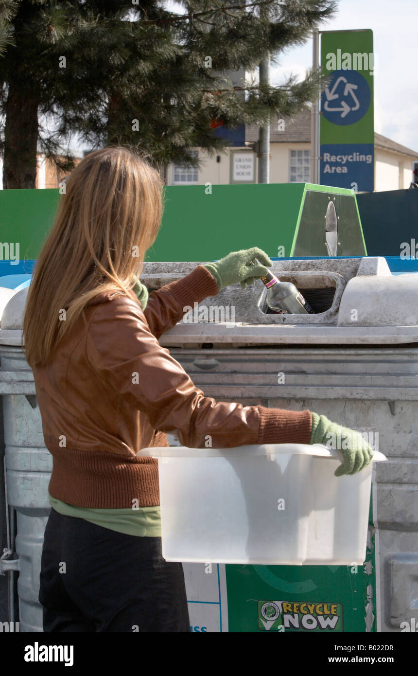 Woman recycling glass at a bottle bank Stock Photo - Alamy