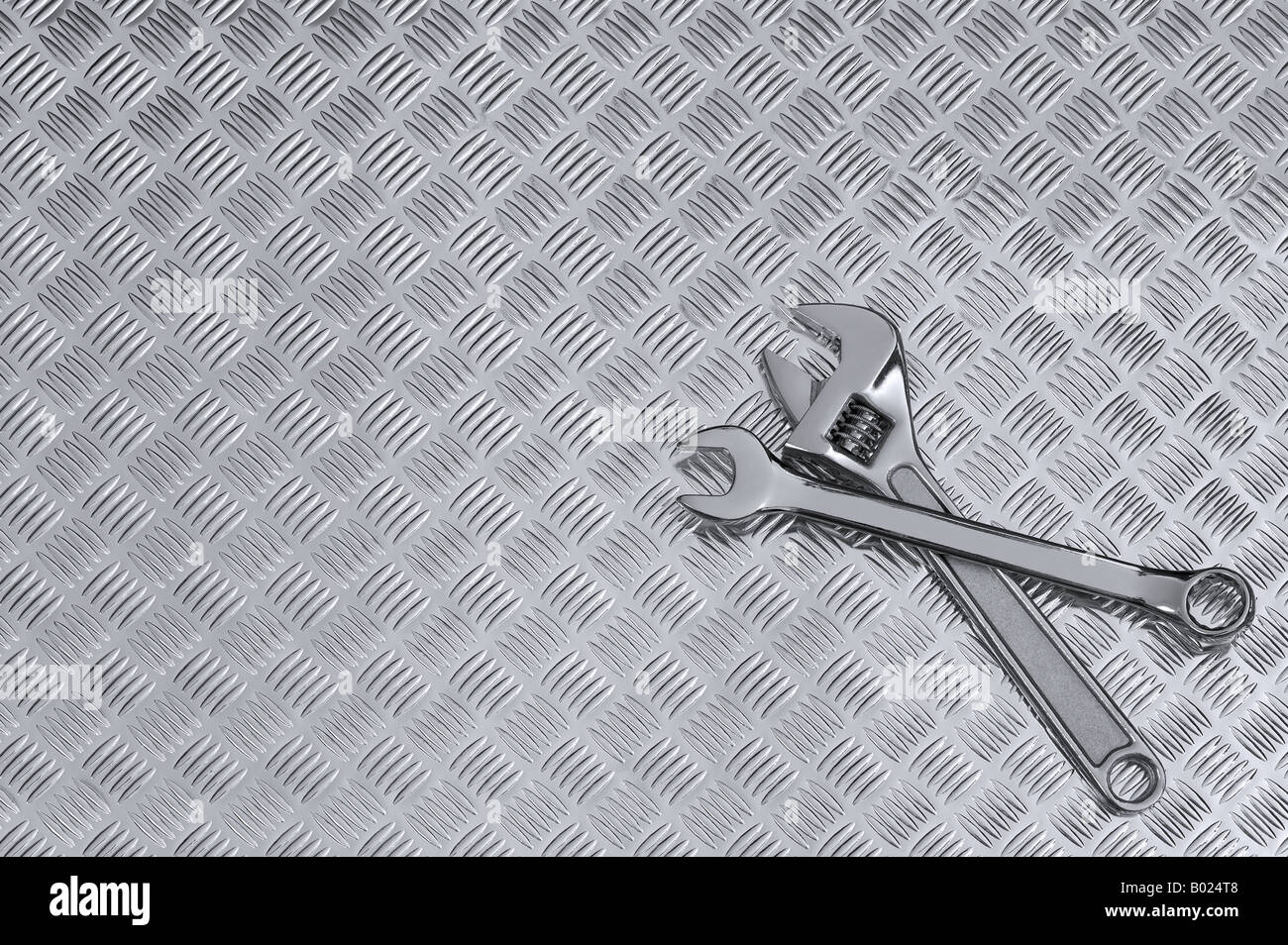 Mechanical background image of two spanners on a checkerplate workbench ...