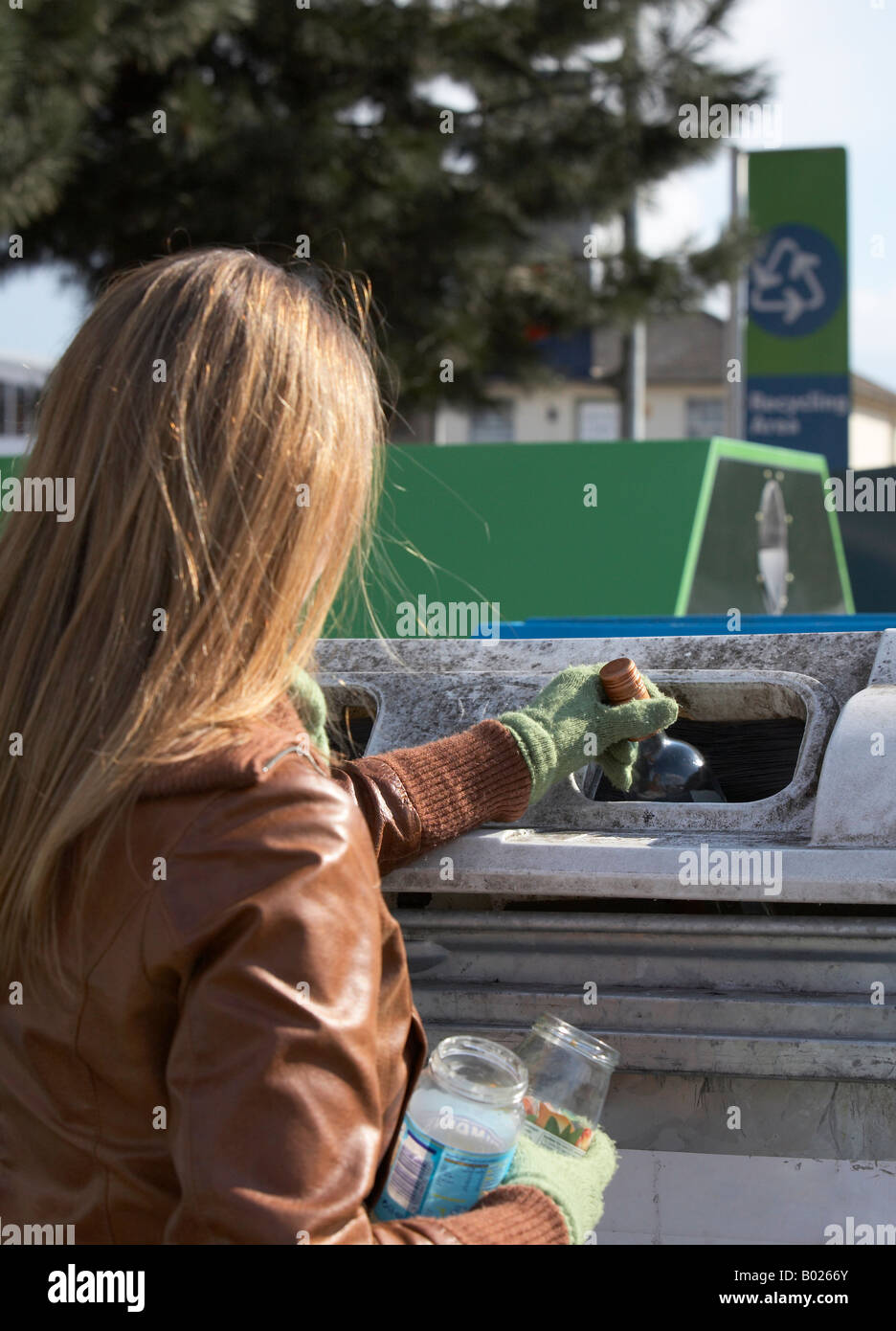 Woman recycling glass at a bottle bank Stock Photo - Alamy