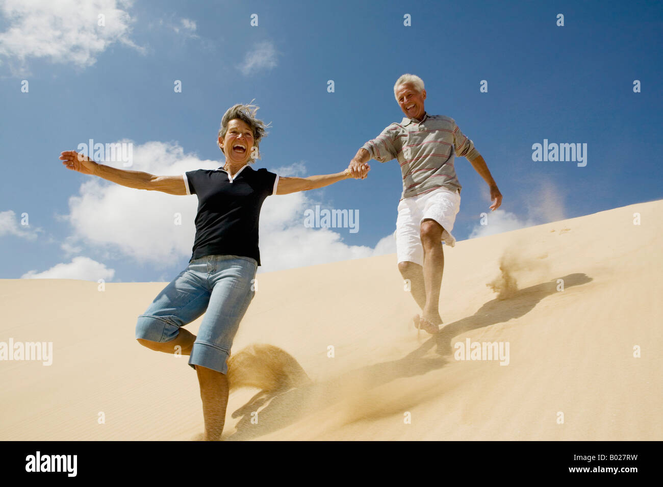 Couple holding hands running down hi-res stock photography and images ...