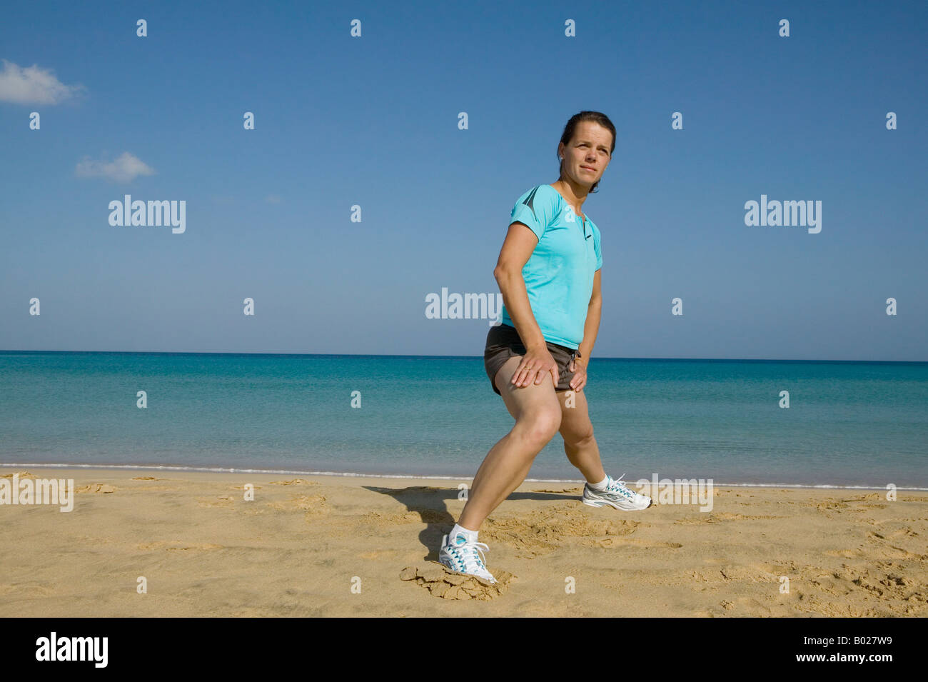 young woman doing stretching exercises on beach Stock Photo - Alamy