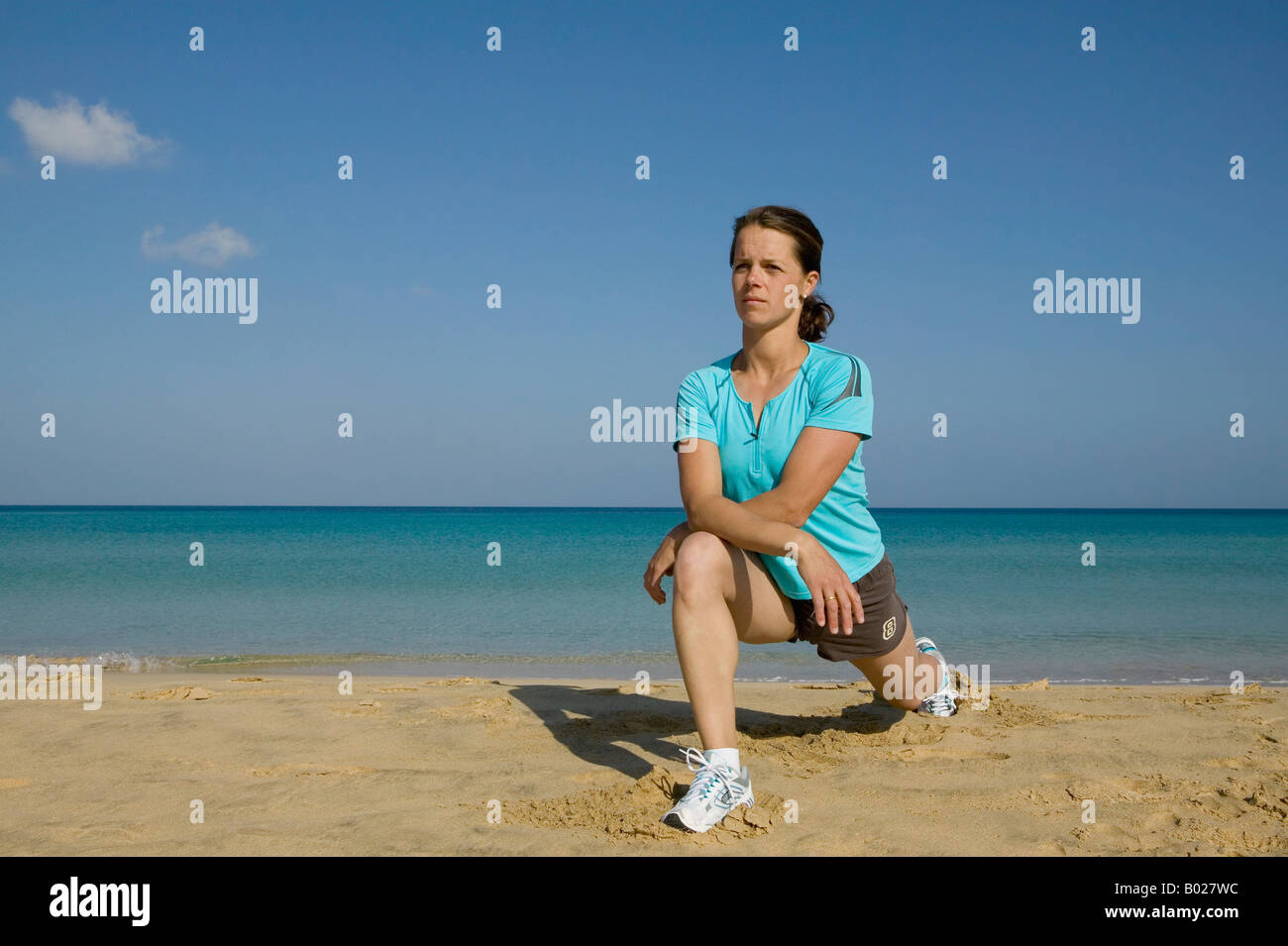 young woman doing stretching exercises on beach Stock Photo - Alamy
