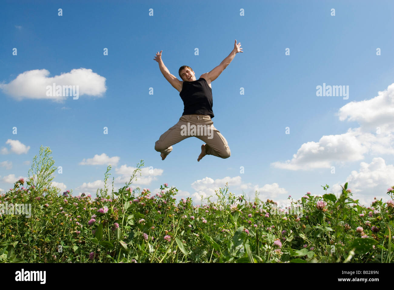 young man jumping in summer meadow Stock Photo - Alamy