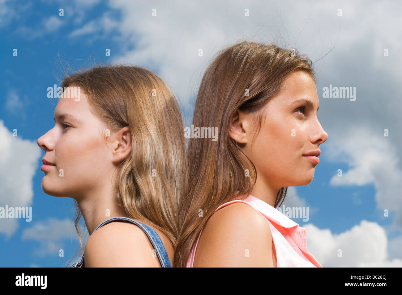 headshot of two young women standing back to back Stock Photo - Alamy