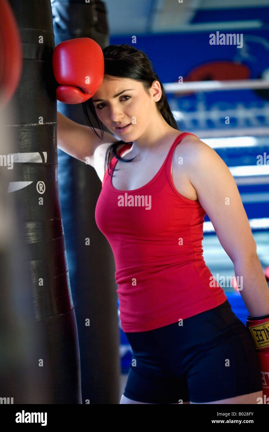 portrait of exhausted female boxer leaning against punching bag Stock ...