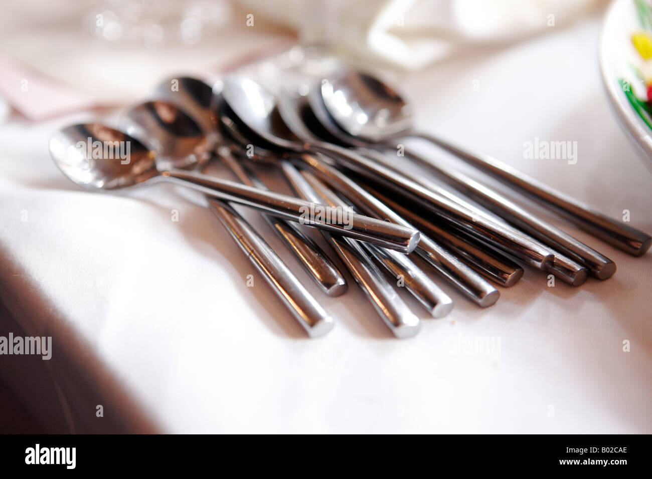 Dessert spoons, on white tablecloth Stock Photo - Alamy