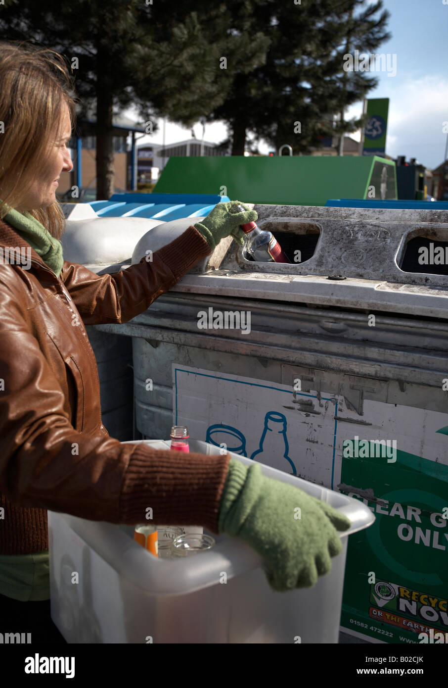 Woman recycling glass at a bottle bank Stock Photo - Alamy