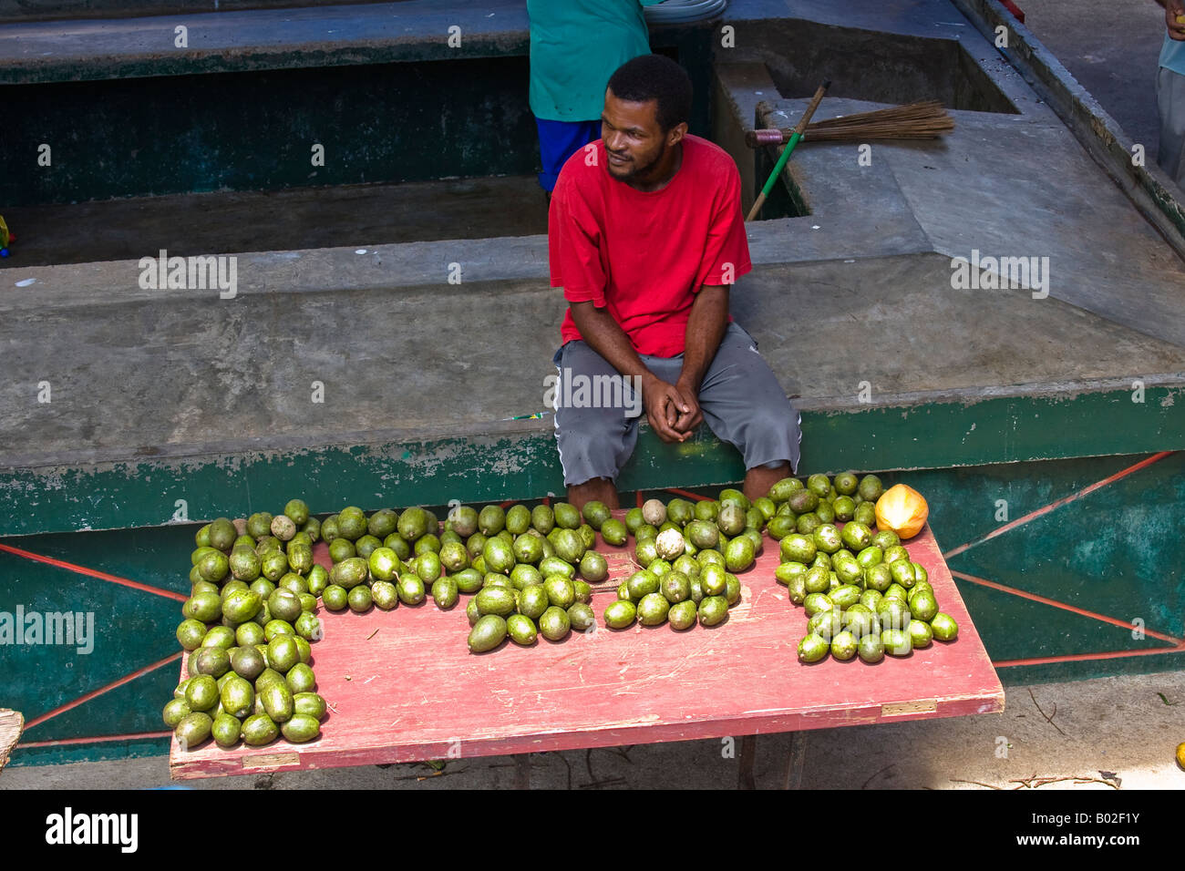 Caribbean market seller selling mangoes Stock Photo - Alamy