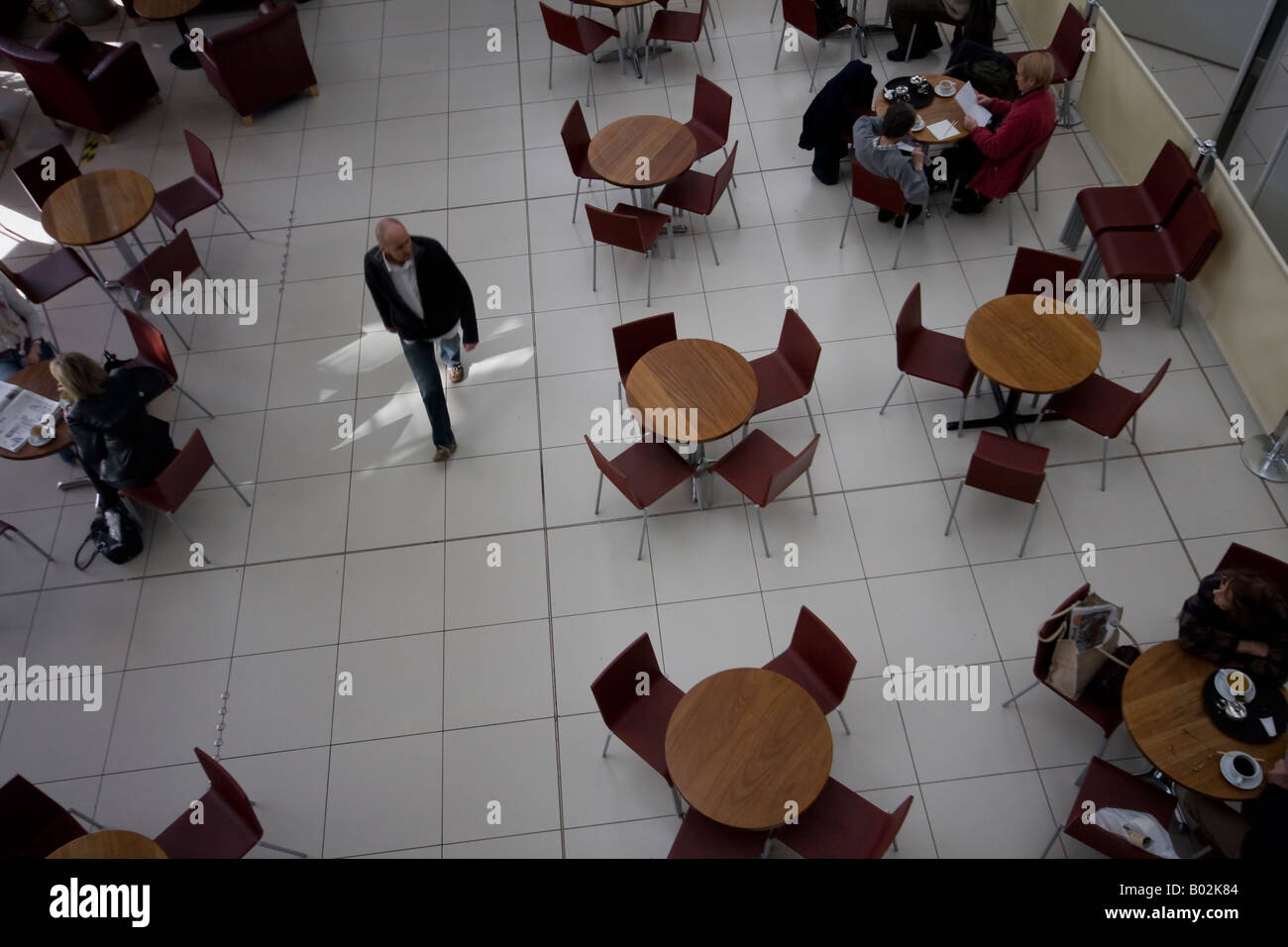 Man walking through the tables and chairs Stock Photo - Alamy